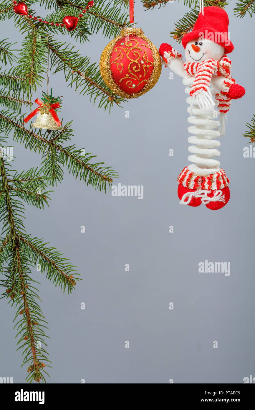 Branches of fir tree with figure of snowman, ball, bell and other ...