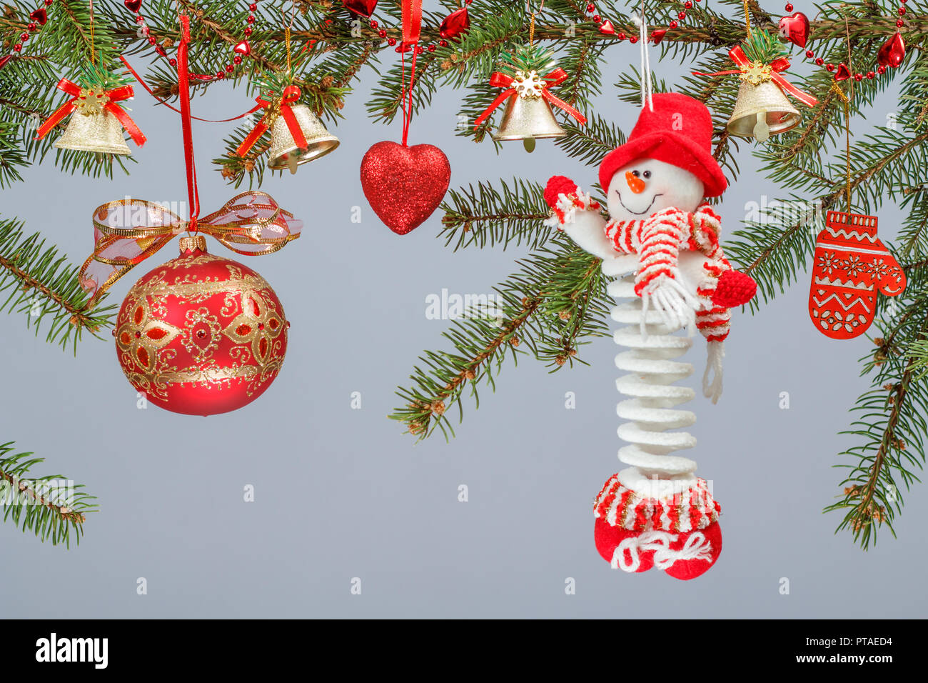 Branches of fir tree with figure of snowman, ball, bells and other ...