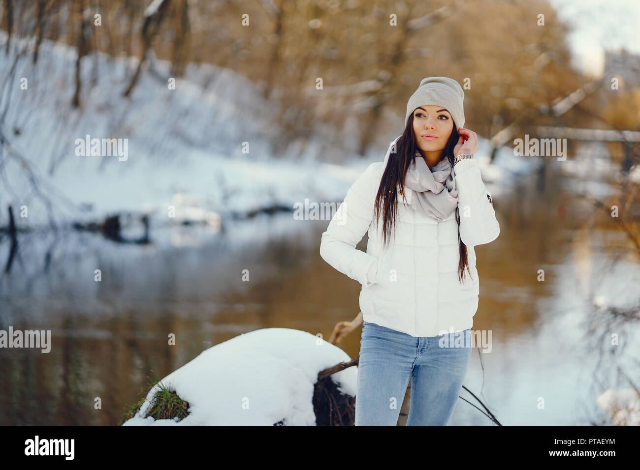 young and stylish girl snadning in a winter snowy park neaw water Stock ...