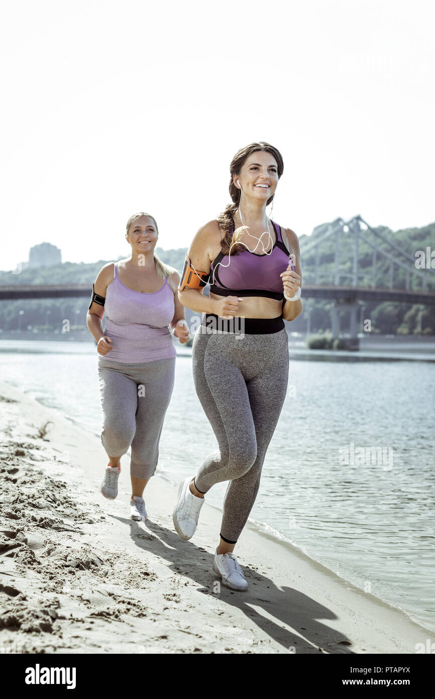 Delighted nice woman being faster than her friend Stock Photo - Alamy