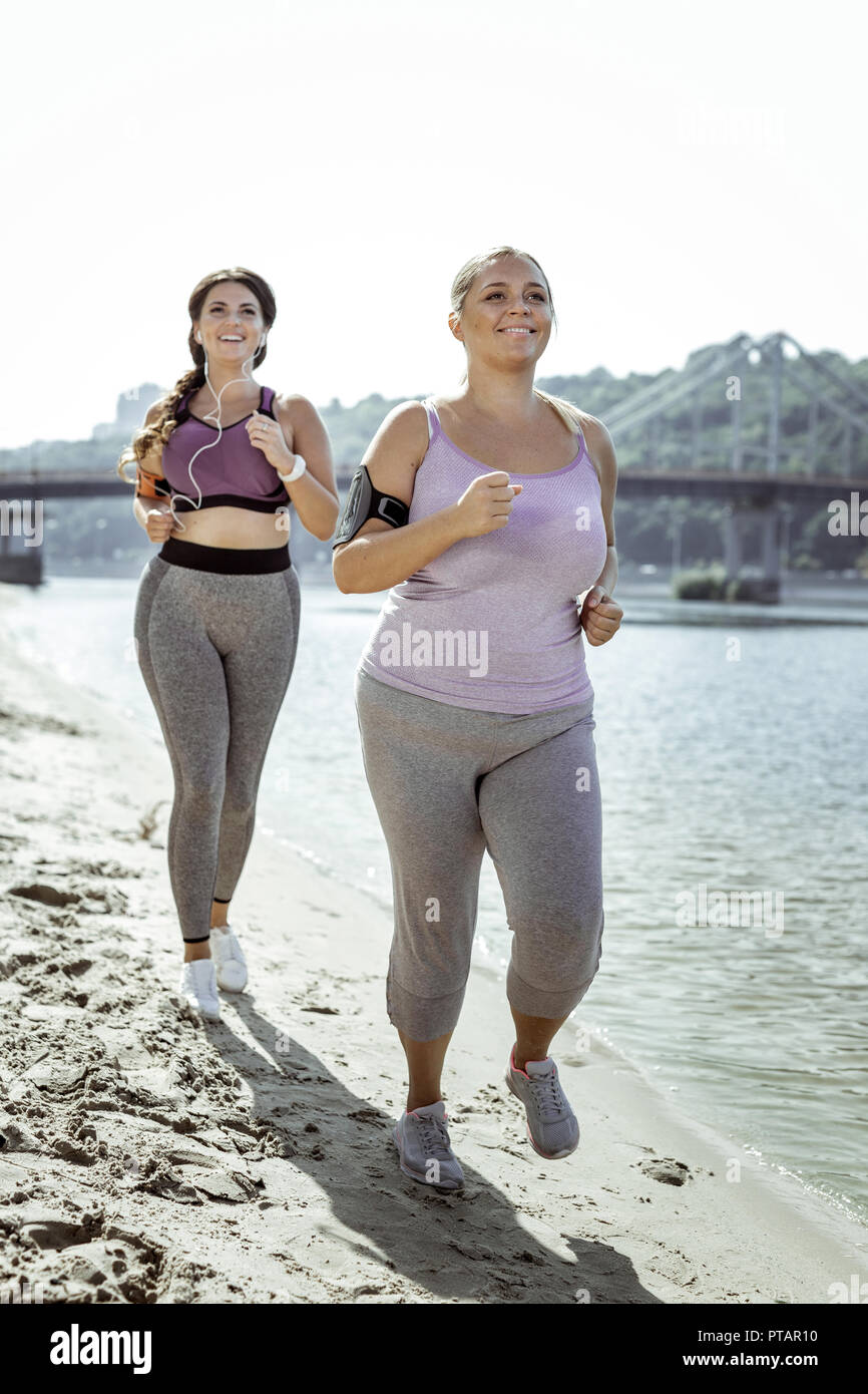 Happy active women jogging near the river Stock Photo - Alamy