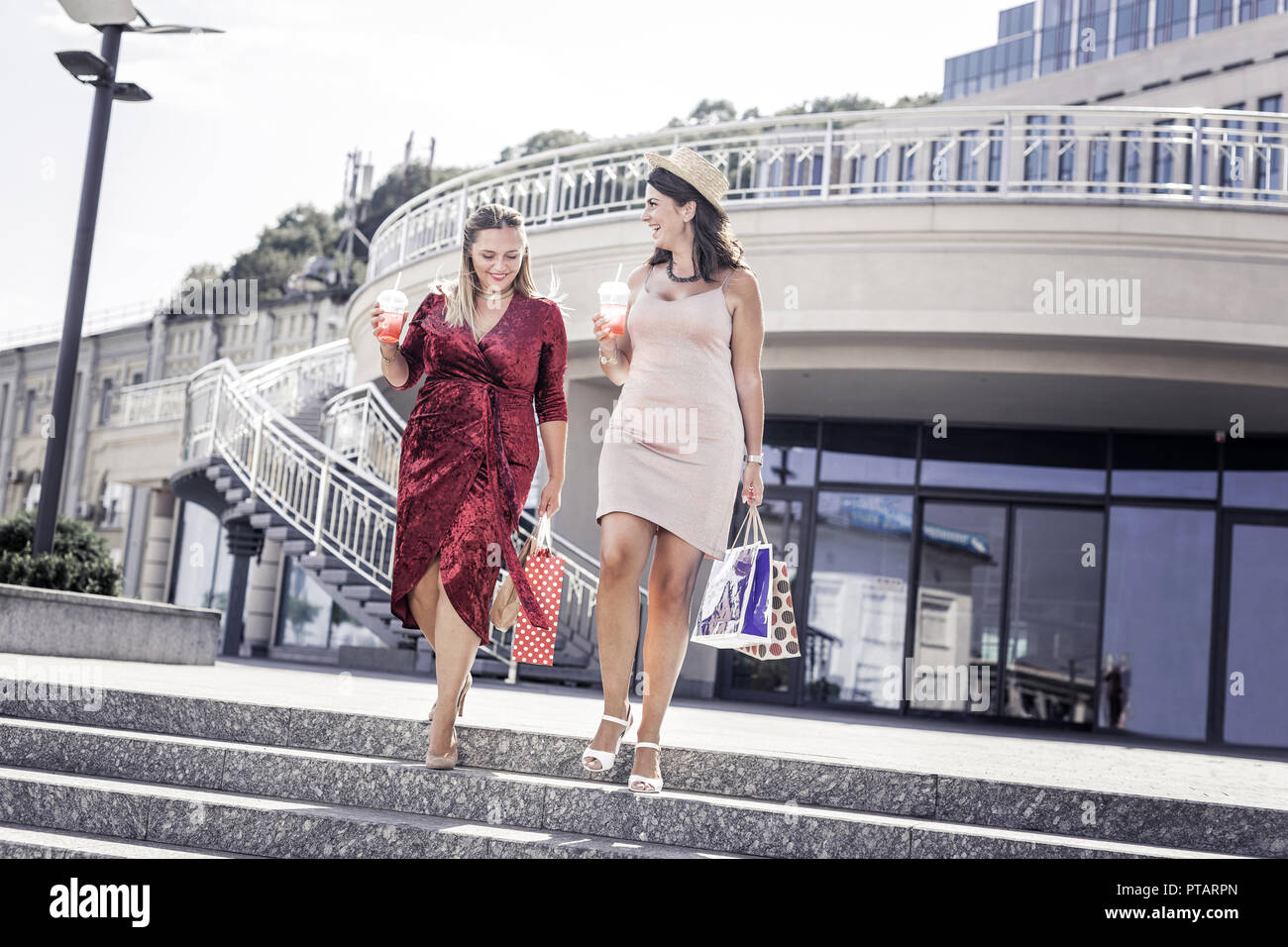 Joyful nice female friends going shopping together Stock Photo - Alamy