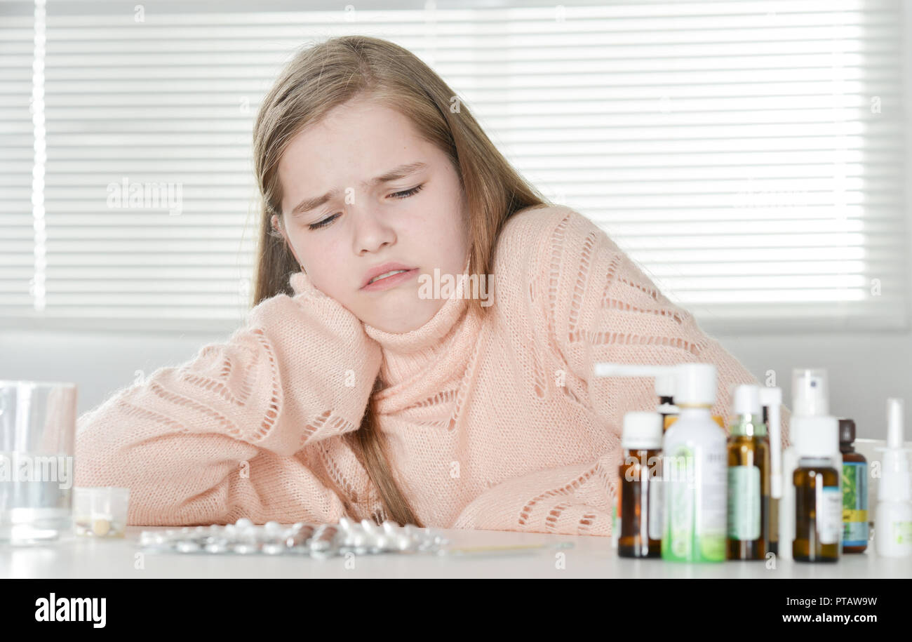 Portrait of a cute little girl taking medicine at home Stock Photo - Alamy