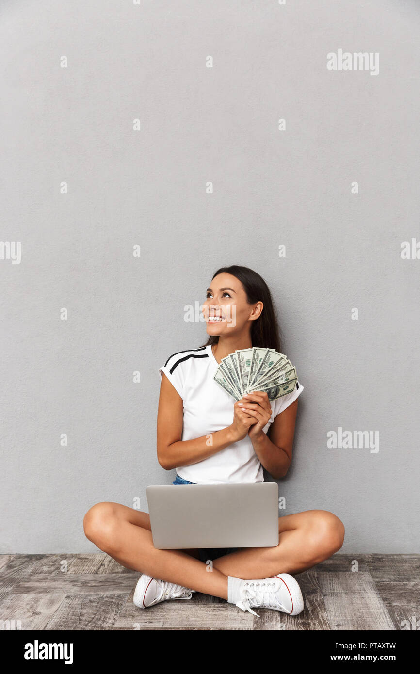 Image of excited happy young woman sitting isolated over grey ...