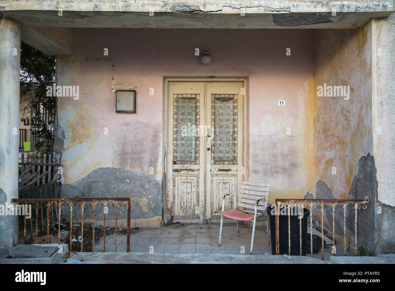 Front porch of a dilapidated house property with flaking or crumbling ...