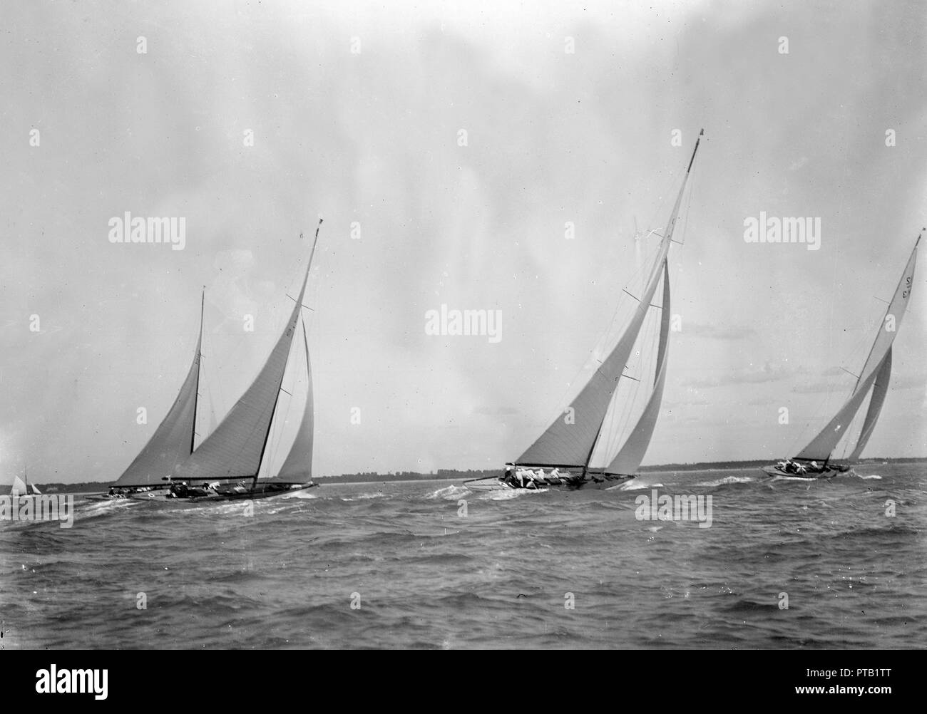 A group of 12 Metres sailing yachts racing on windward leg in good wind ...
