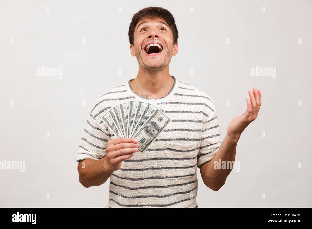 Portrait of a happy young man standing isolated over white background ...