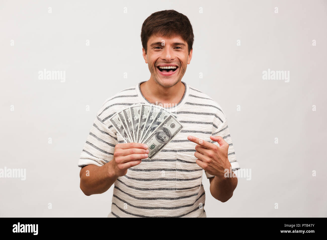 Portrait of a cheerful young man standing isolated over white ...