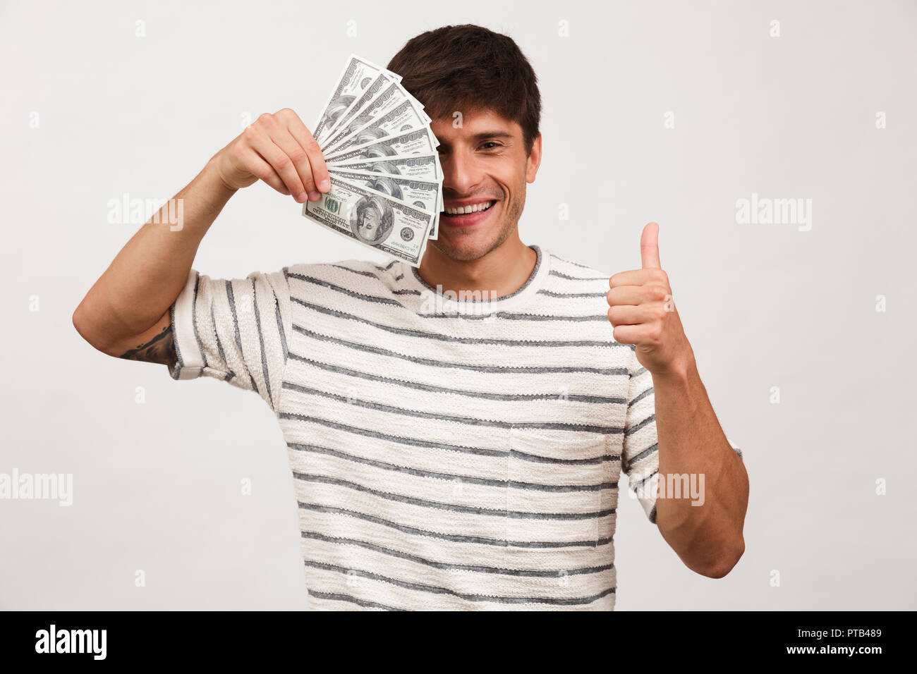 Portrait of a cheerful young man standing isolated over white ...