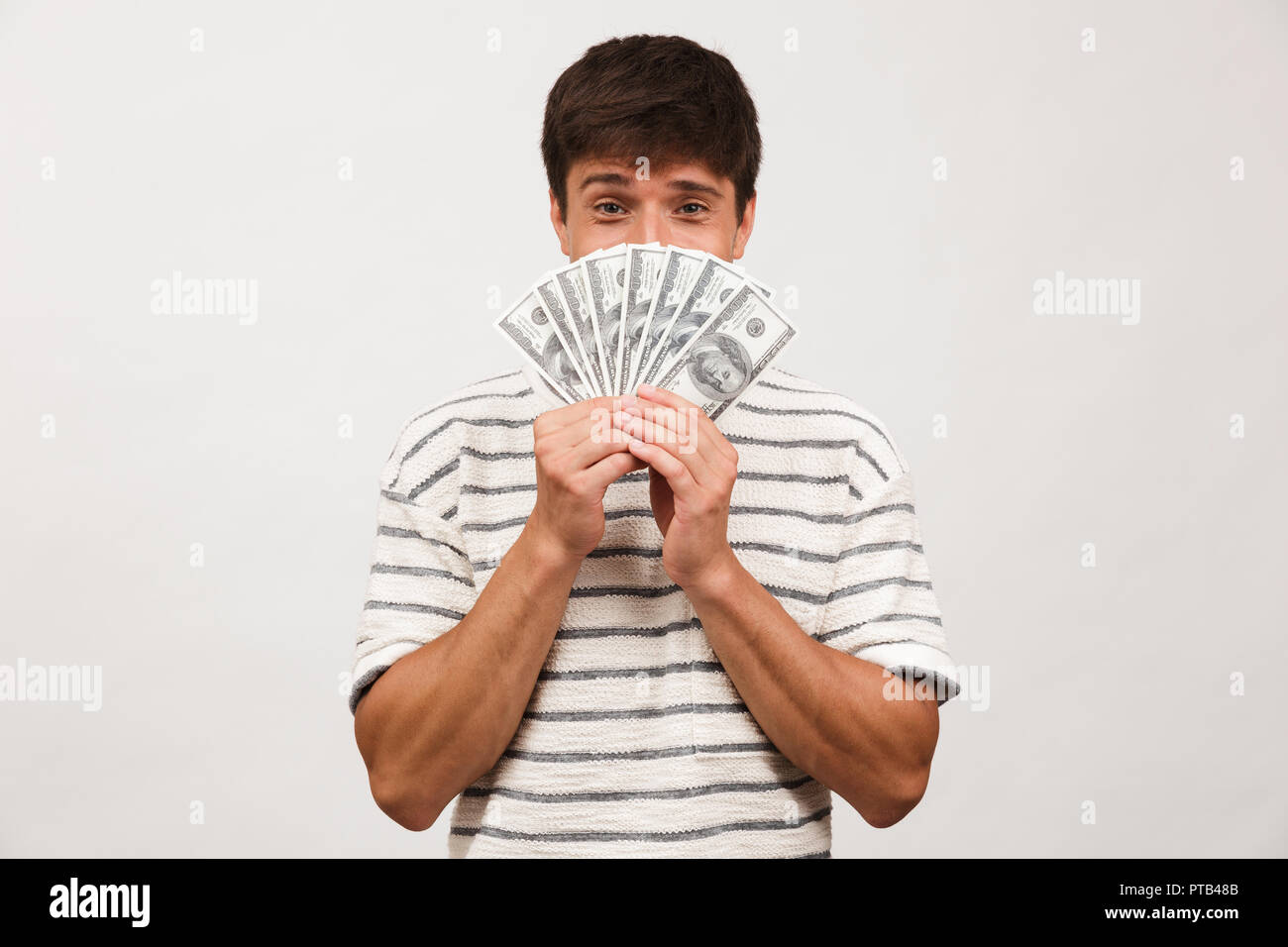 Portrait of a happy young man standing isolated over white background ...
