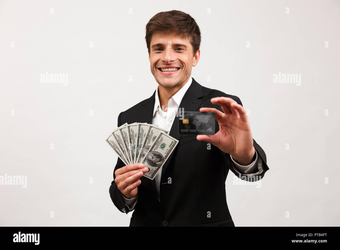 Image of handsome happy businessman standing isolated holding money and ...