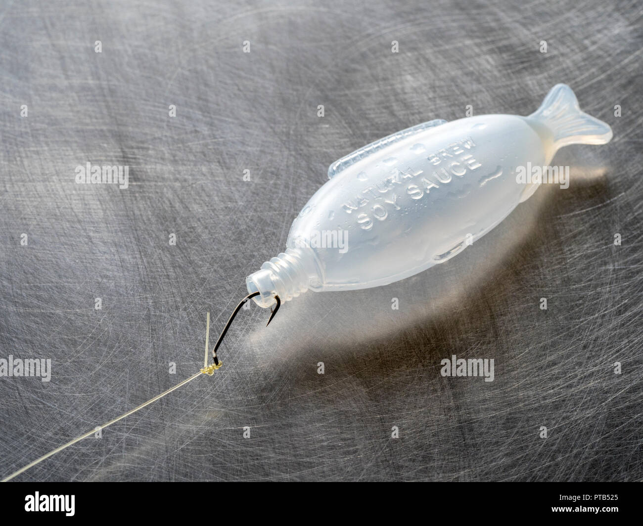 Empty fish shaped Soy sauce bottle with a fishing hook caught in it's ...
