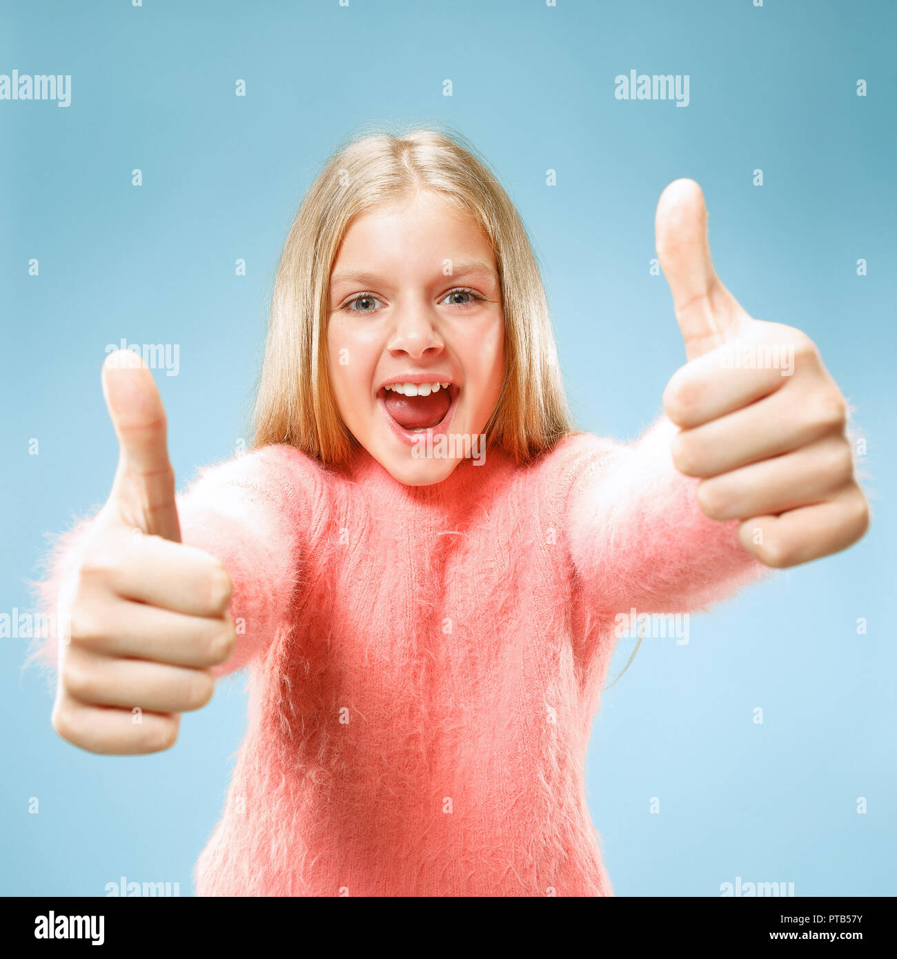 Happy teen girl standing, smiling isolated on trendy blue studio ...