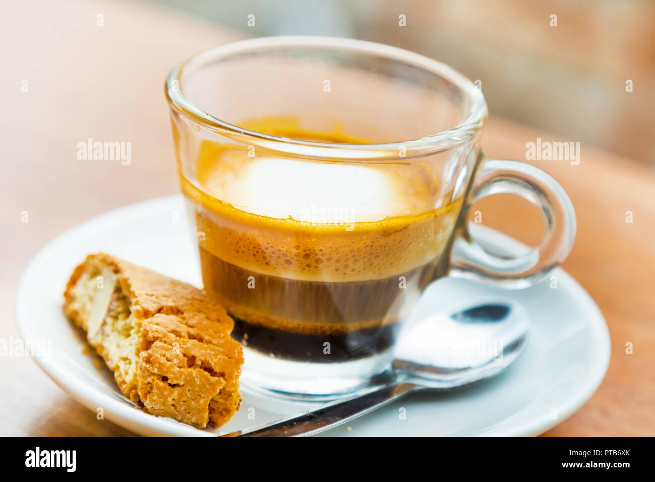 Macchiato coffee in the small glass cup and piece of nut cake Stock ...
