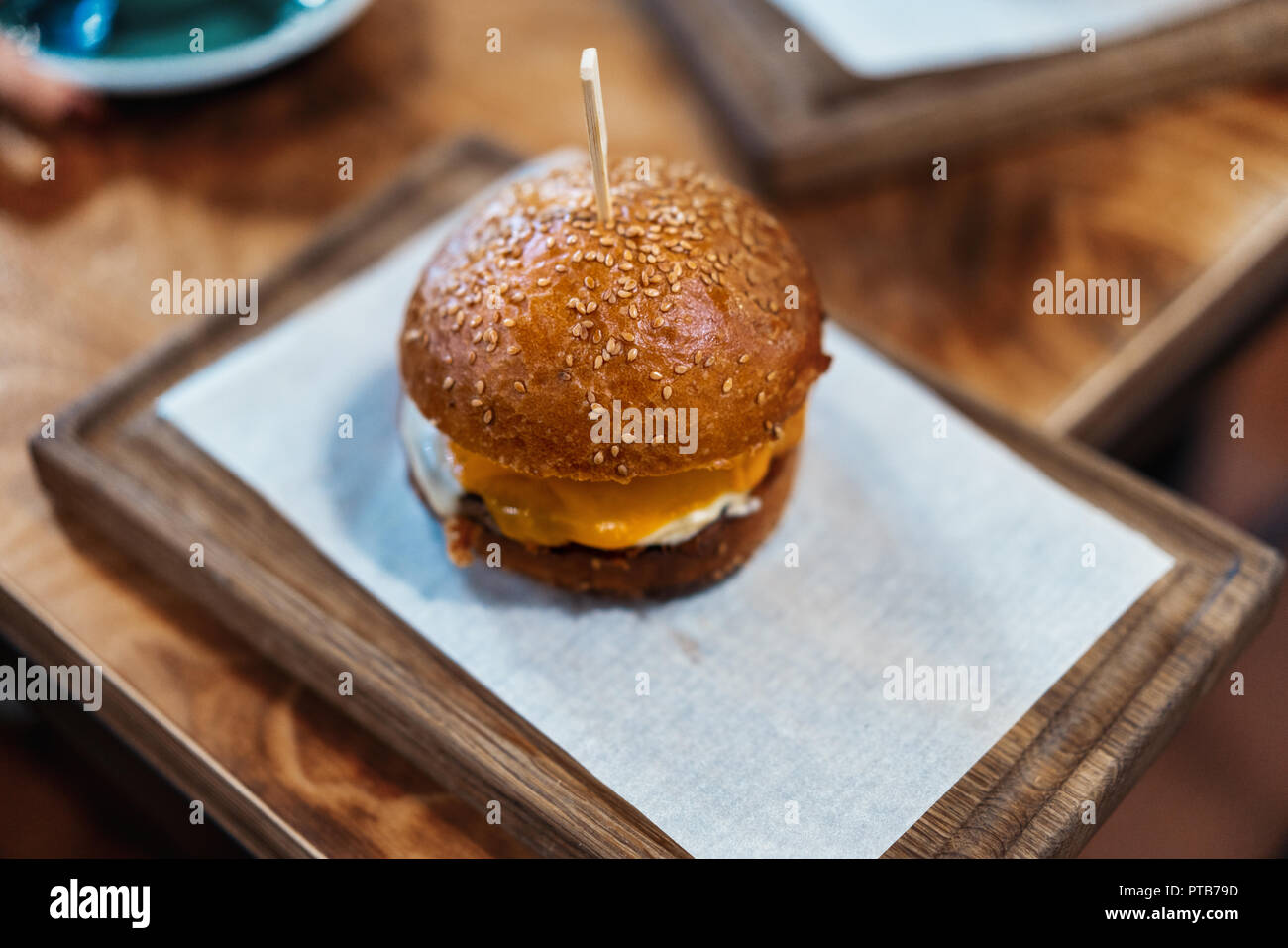 Close up of fresh juicy burger on wooden cutting board in cafe Stock ...