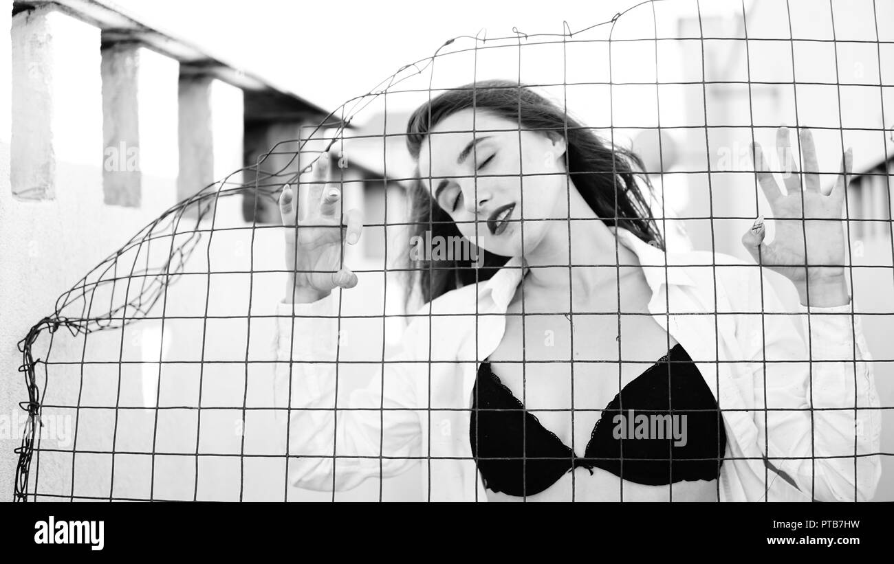 A girl behind a grid in a park posing in a day with a sunlight Stock ...