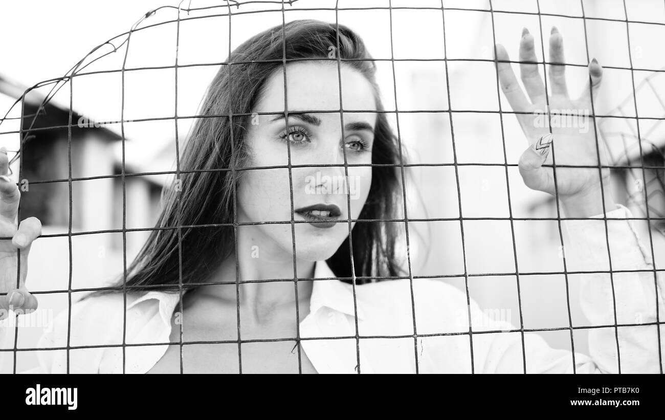 A girl behind a grid in a park posing in a day with a sunlight Stock ...