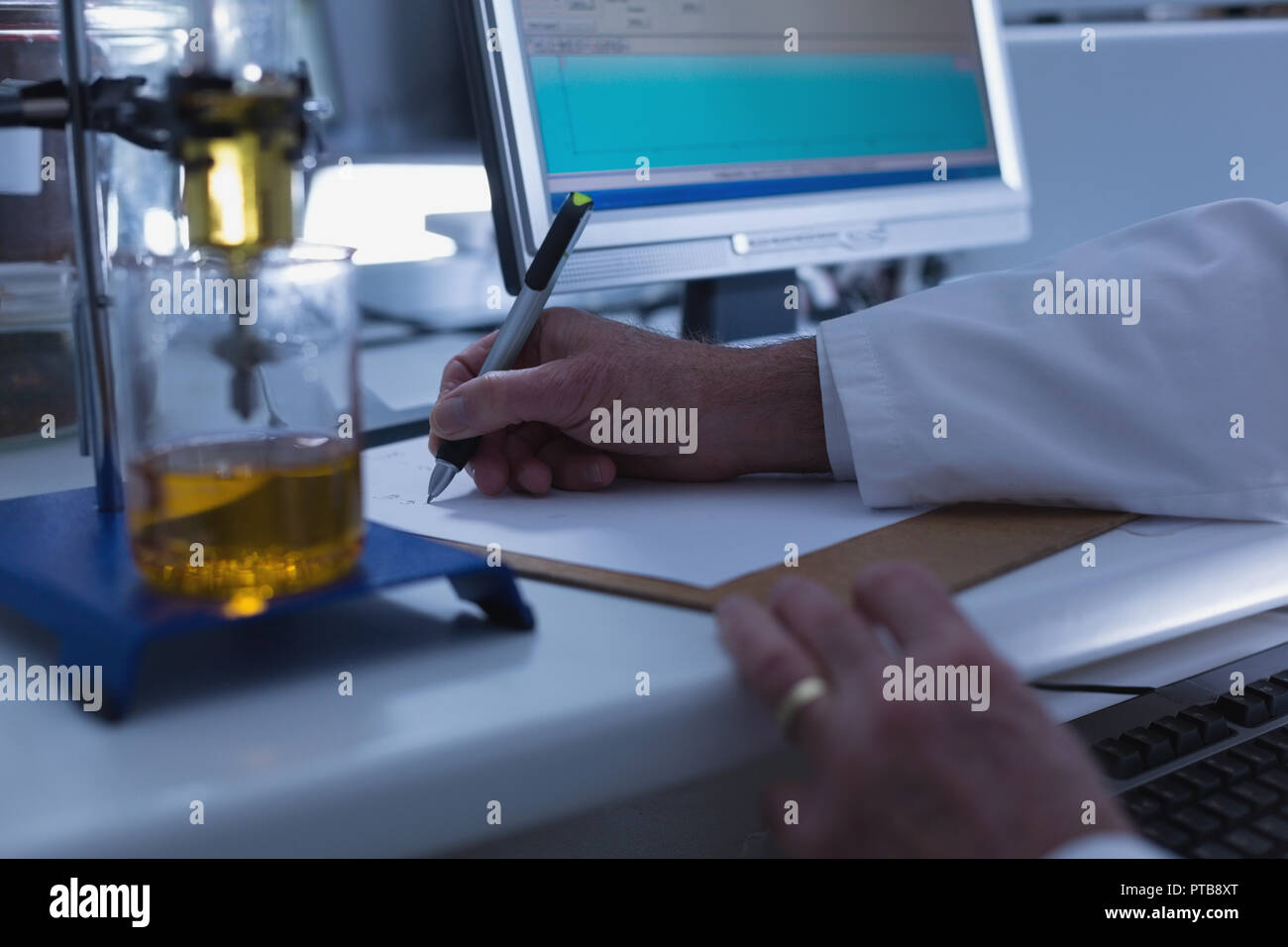 Male scientist writing on clipboard in laboratory Stock Photo - Alamy