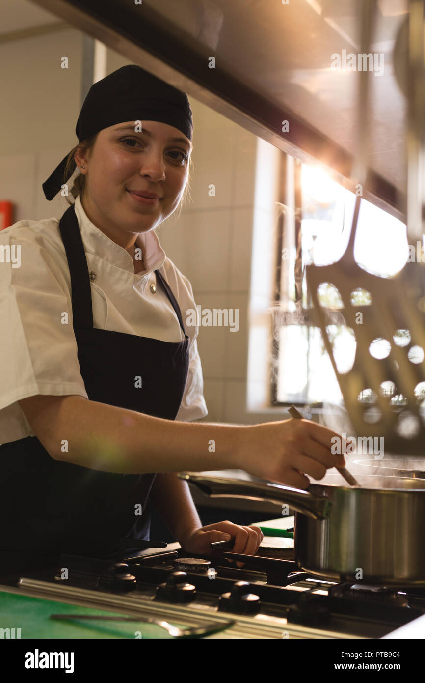 Female chef tasting food in kitchen Stock Photo - Alamy