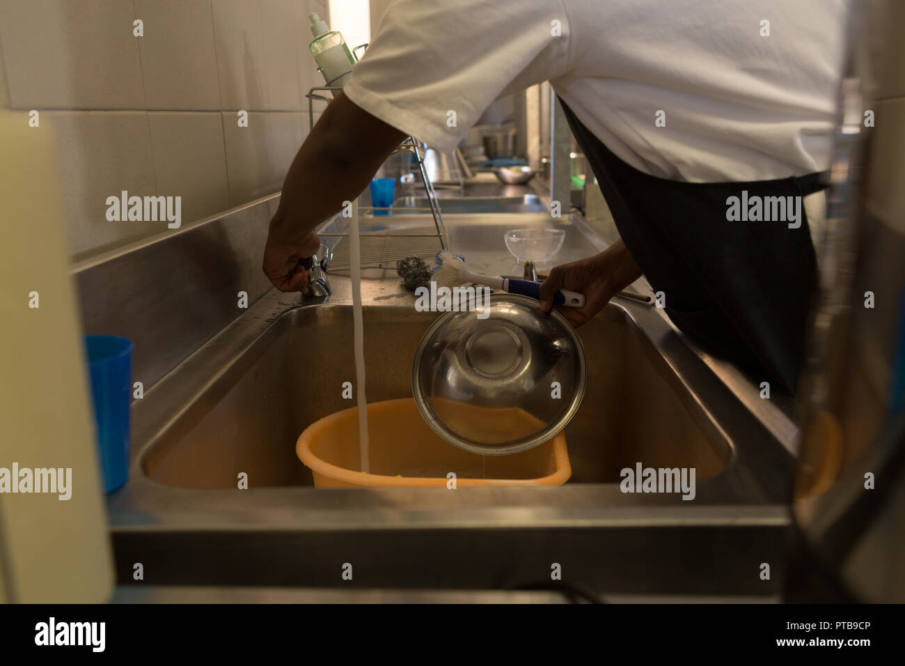 Chef washing utensil in kitchen Stock Photo - Alamy