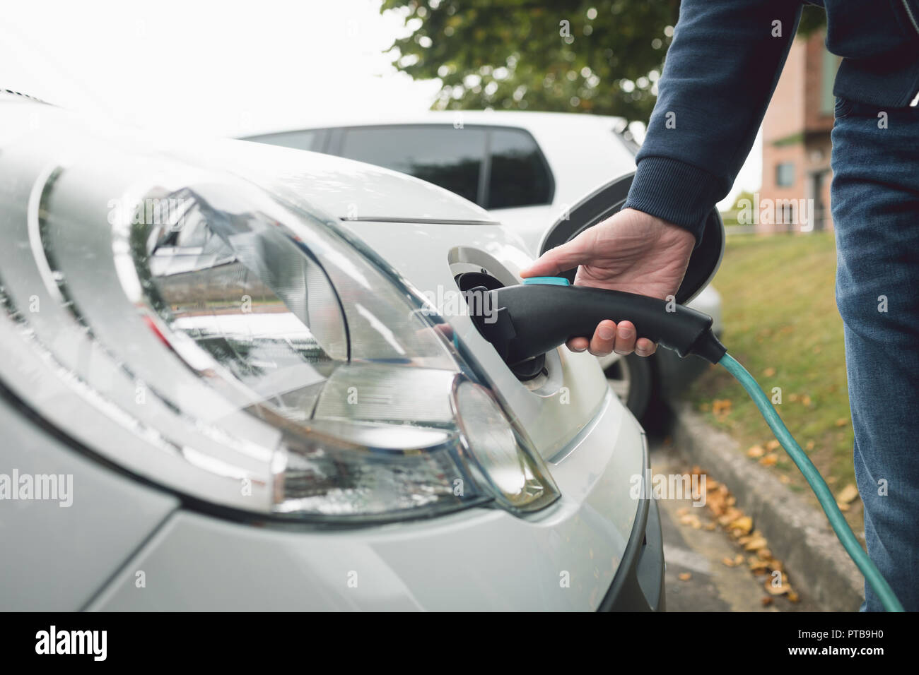 Man charging electric car at charging station Stock Photo - Alamy