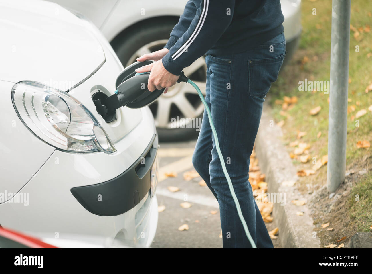Man charging electric car at charging station Stock Photo - Alamy