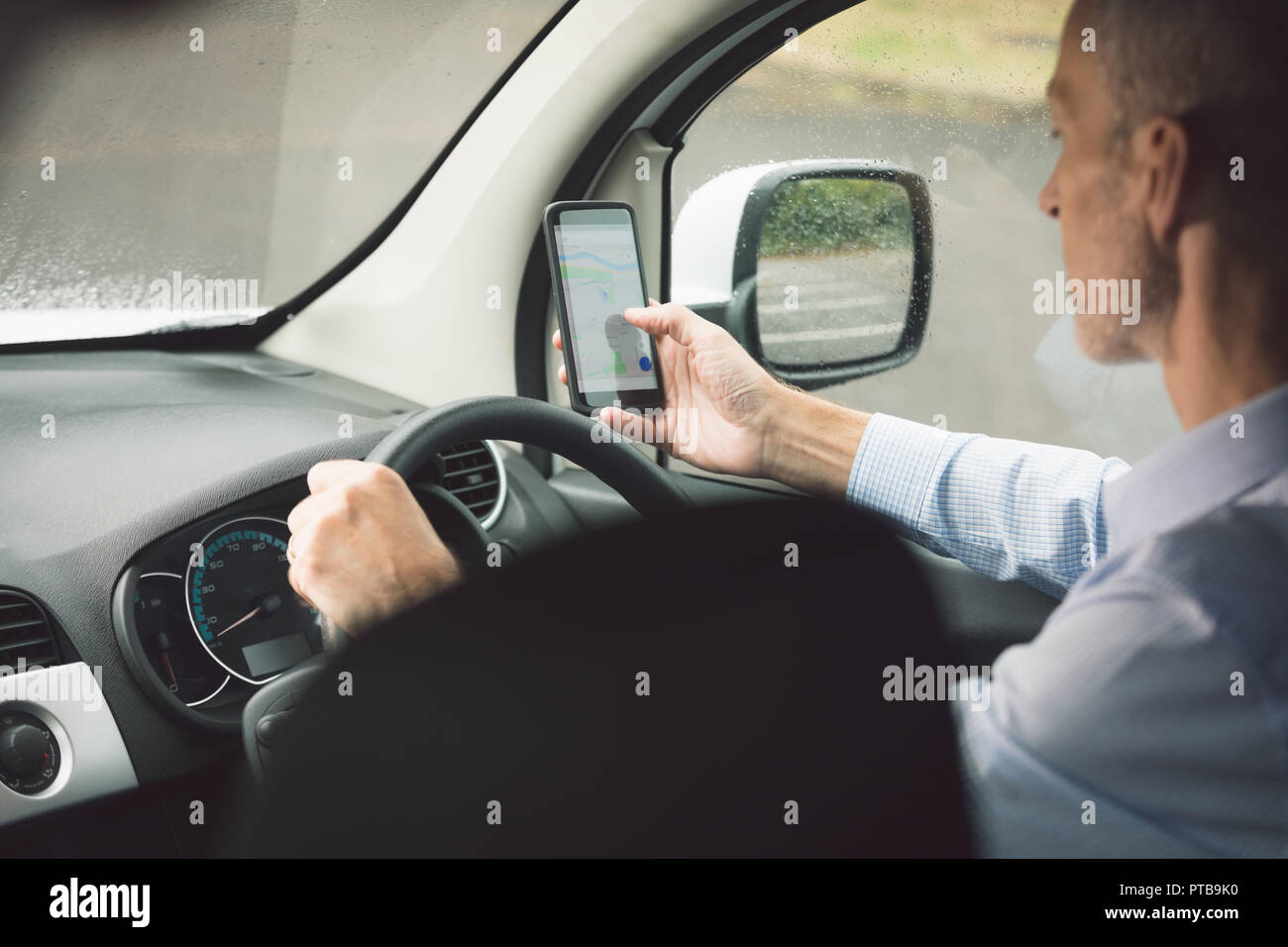 Delivery man using mobile phone while driving a delivery van Stock ...