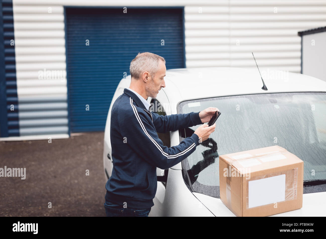 Delivery man using mobile phone Stock Photo - Alamy