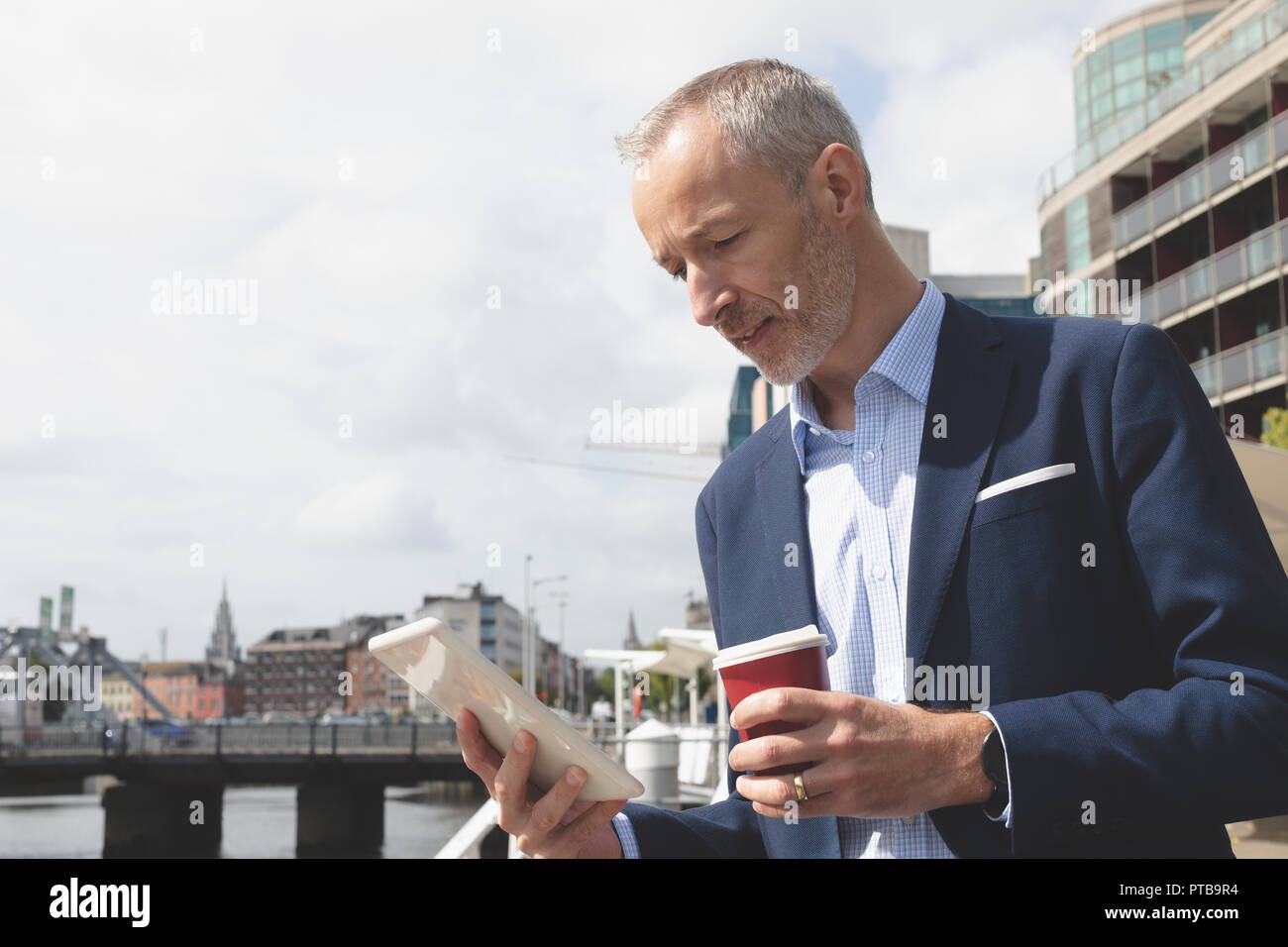 Businessman using digital tablet at promenade Stock Photo - Alamy
