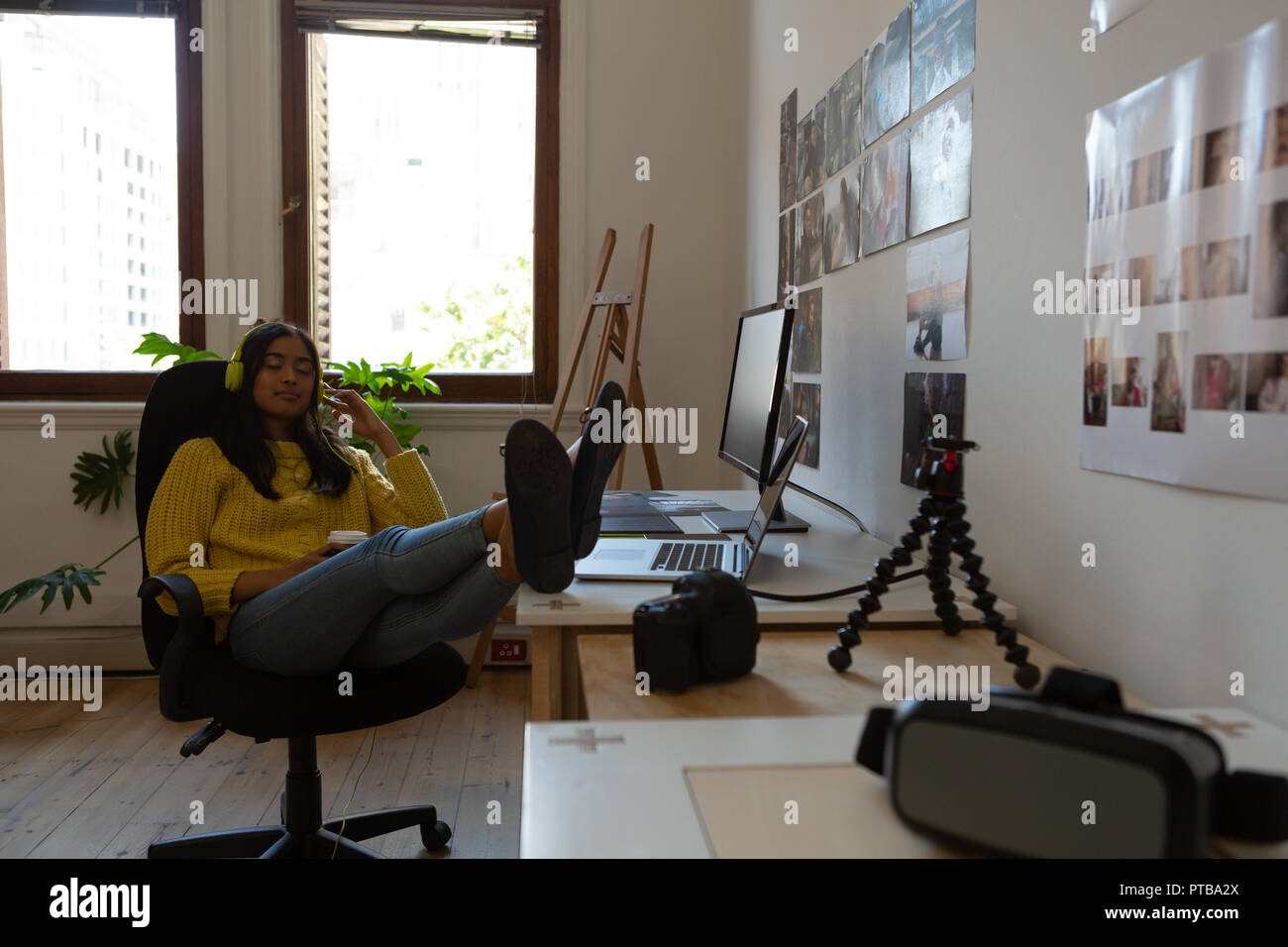 Female executive listening music in office Stock Photo - Alamy