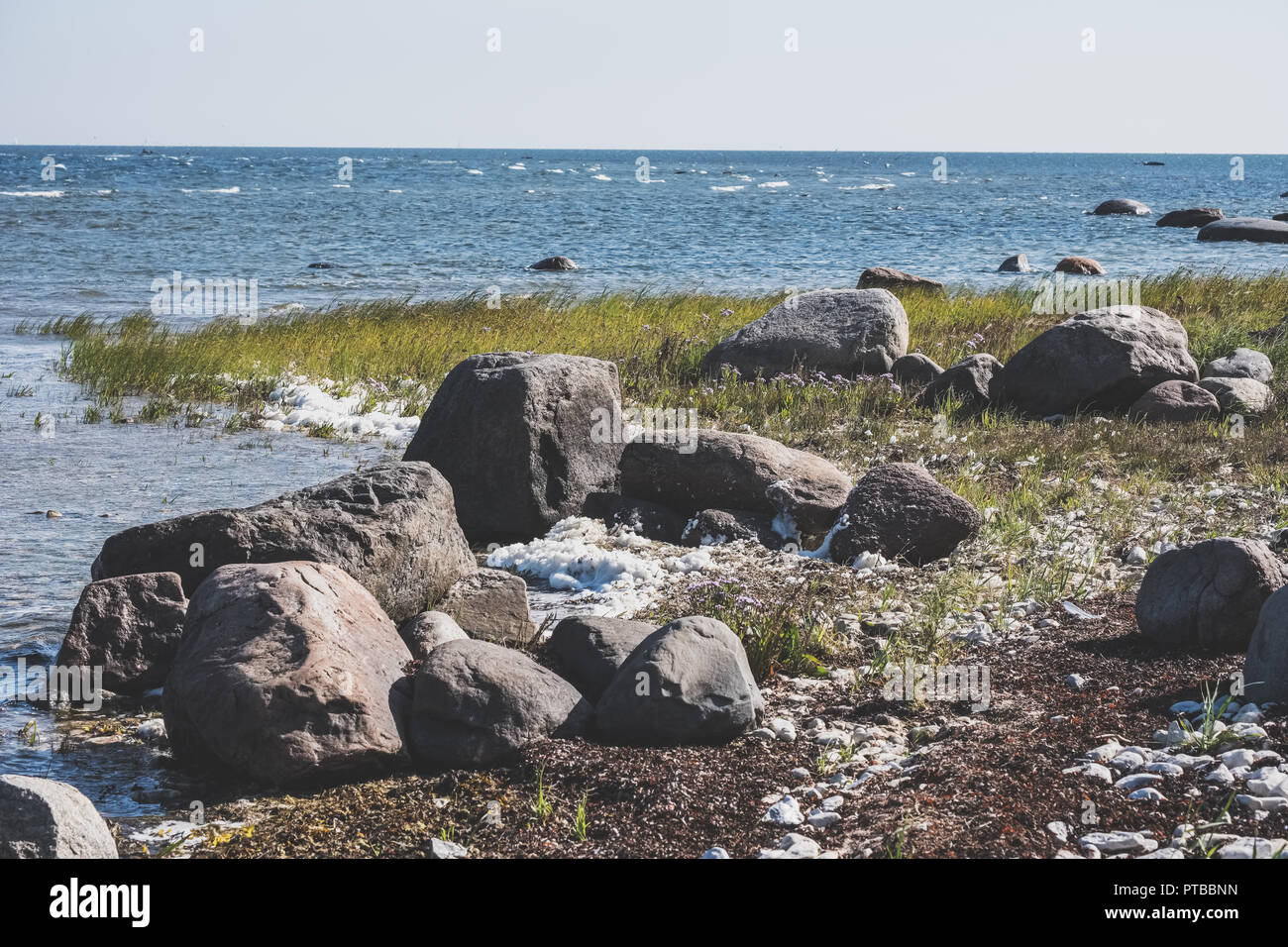 rocky sea beach with wide angle perspective over the sea with sunny sky ...