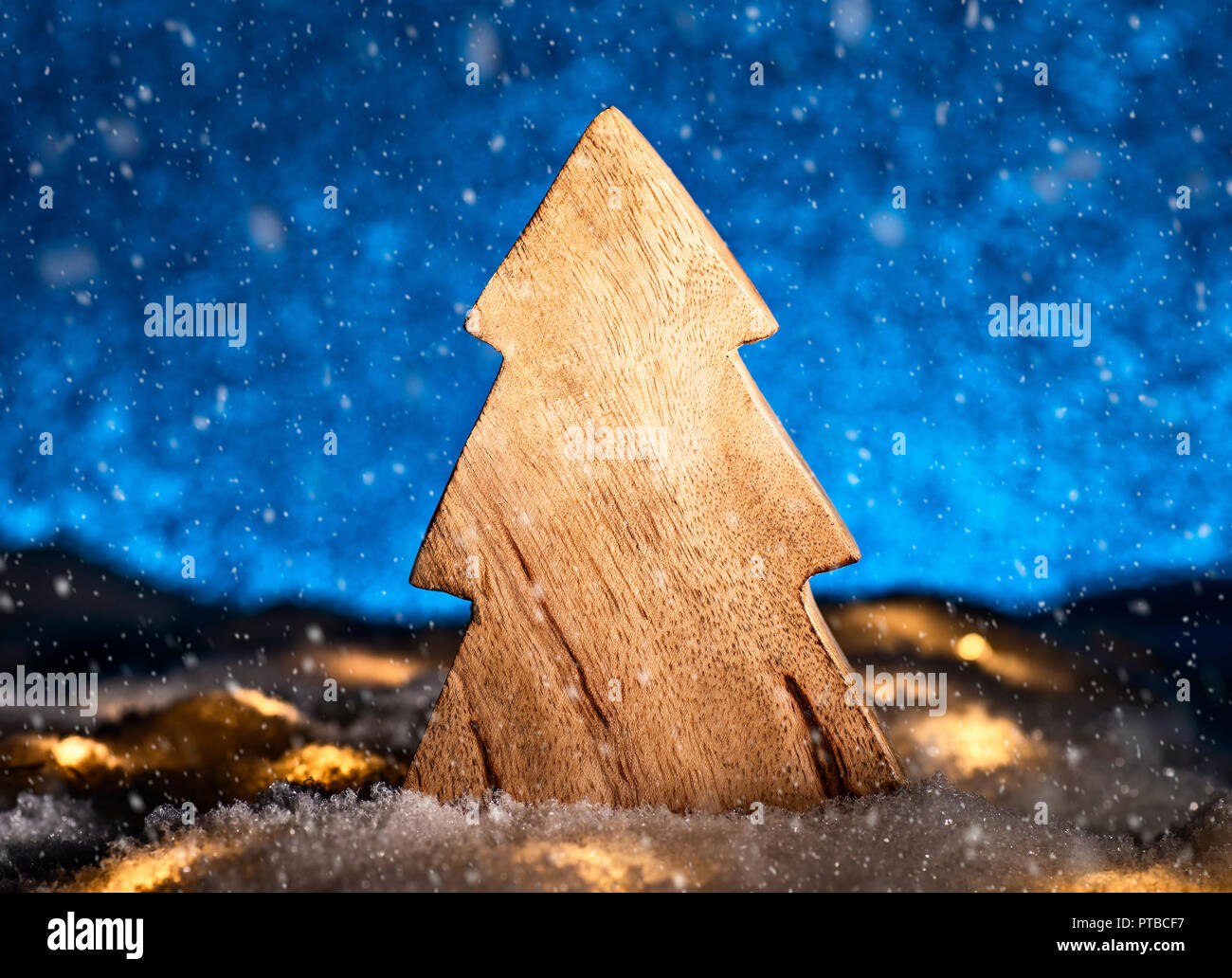 Wooden Christmas tree with snow in front of a blue background Stock ...