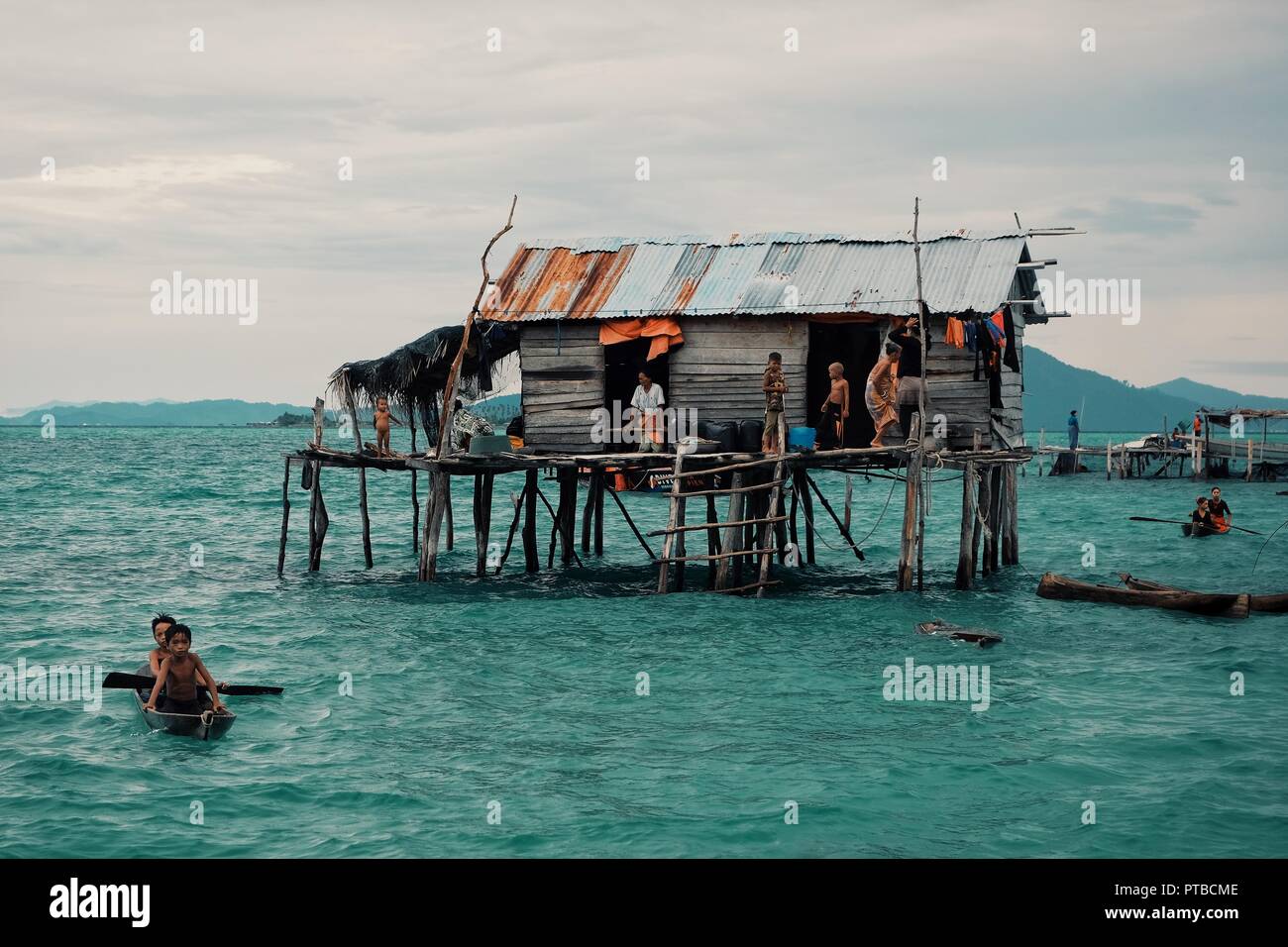 stilt houses in a bajau sea gypsy village next to a small island rock ...