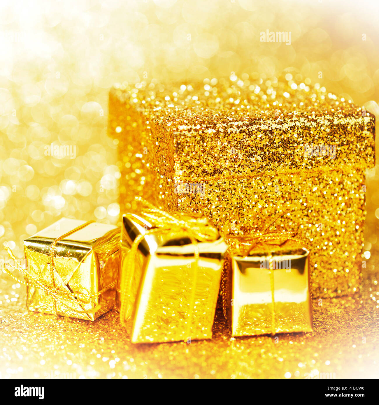 Decorative golden boxes with holiday gifts on shiny glitter background ...