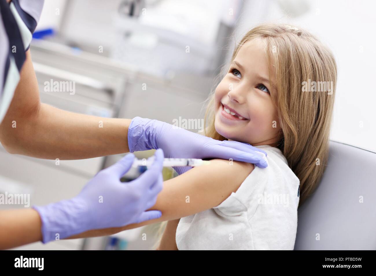 Picture of brave little girl receiving injection or vaccine with a ...