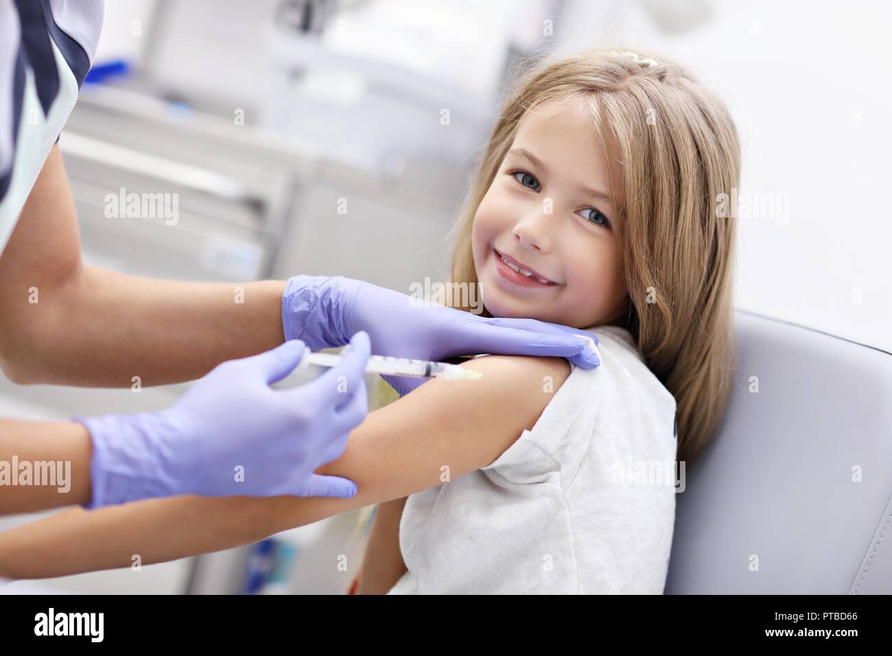 Picture of brave little girl receiving injection or vaccine with a ...