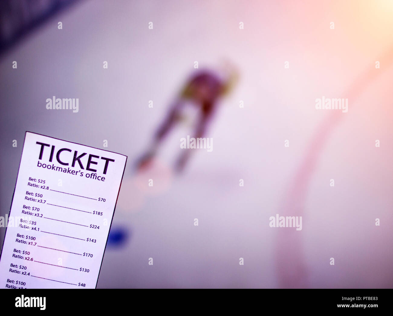 Bookmaker ticket on the background of a TV on which show skating sports ...