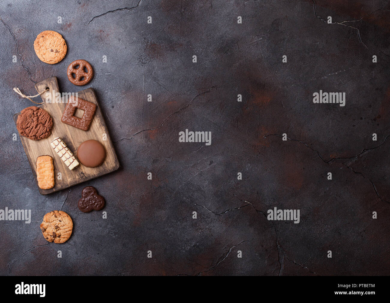 Oat and chocolate cookies selection on wooden board on stone kitchen ...