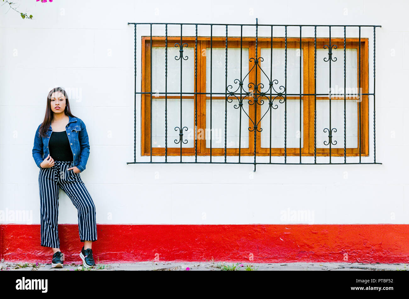 Stylish young woman posing against window outdoors. Fashionable outfit ...
