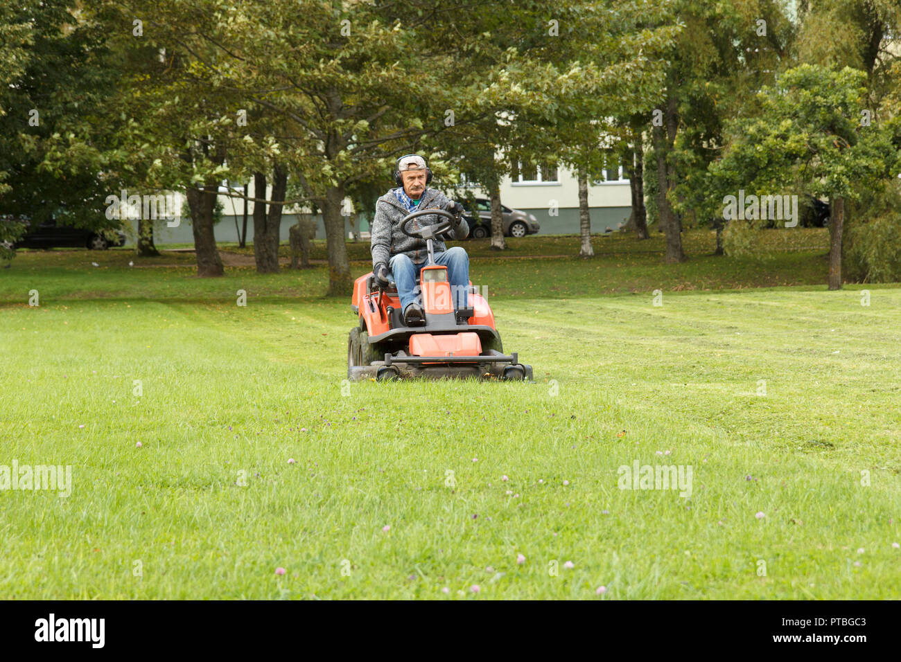lawn mower tractor working in the town park Stock Photo - Alamy