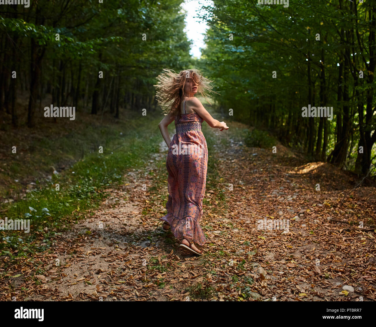 Scared woman running through the forest Stock Photo - Alamy
