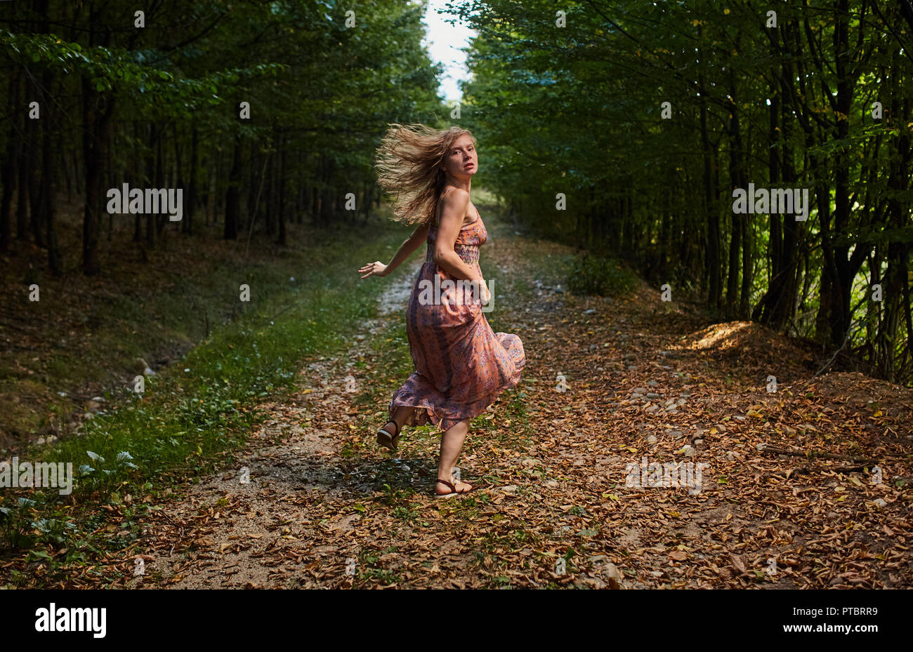 Scared woman running through the forest Stock Photo - Alamy