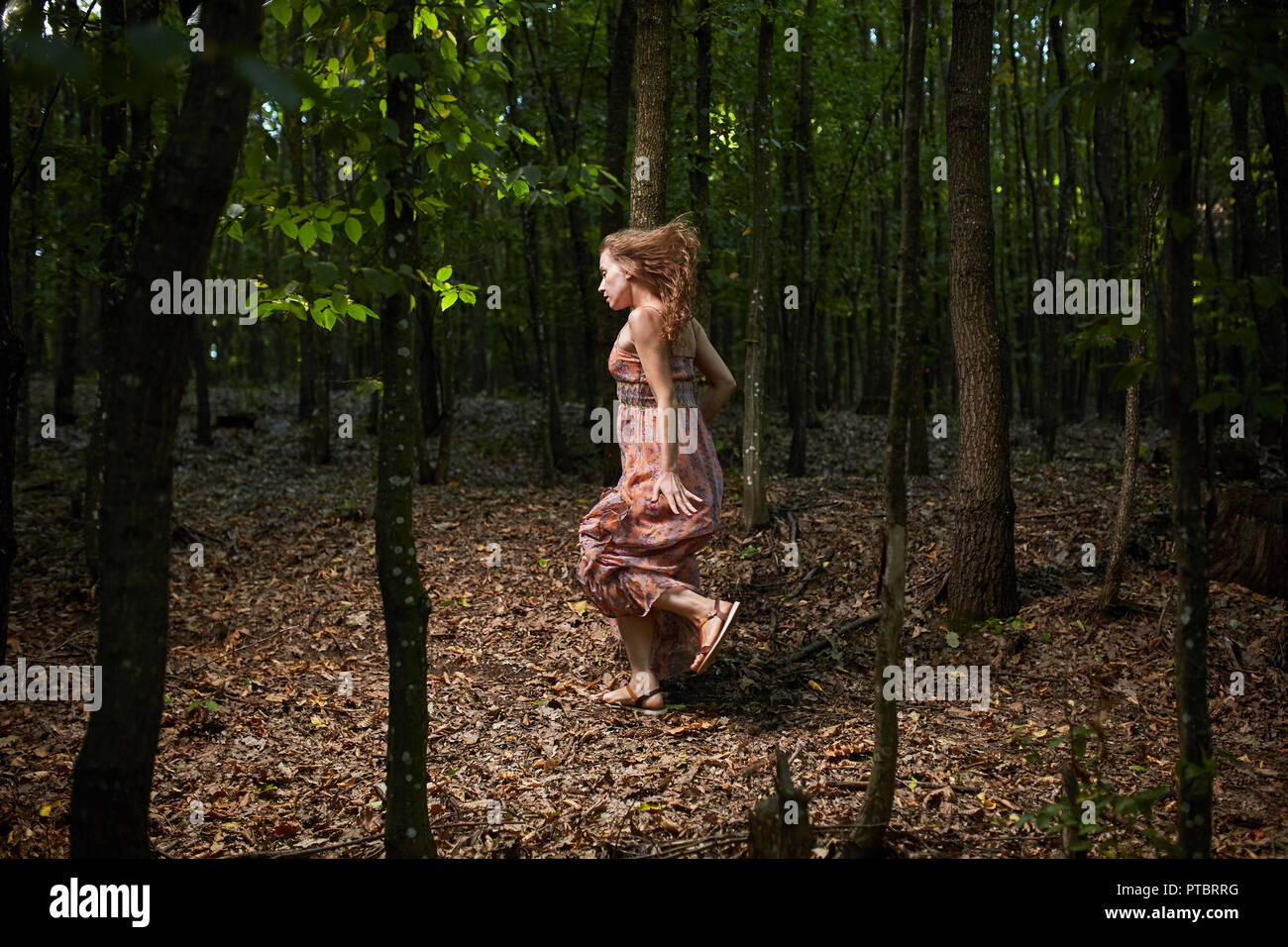 Scared woman running through the forest Stock Photo - Alamy
