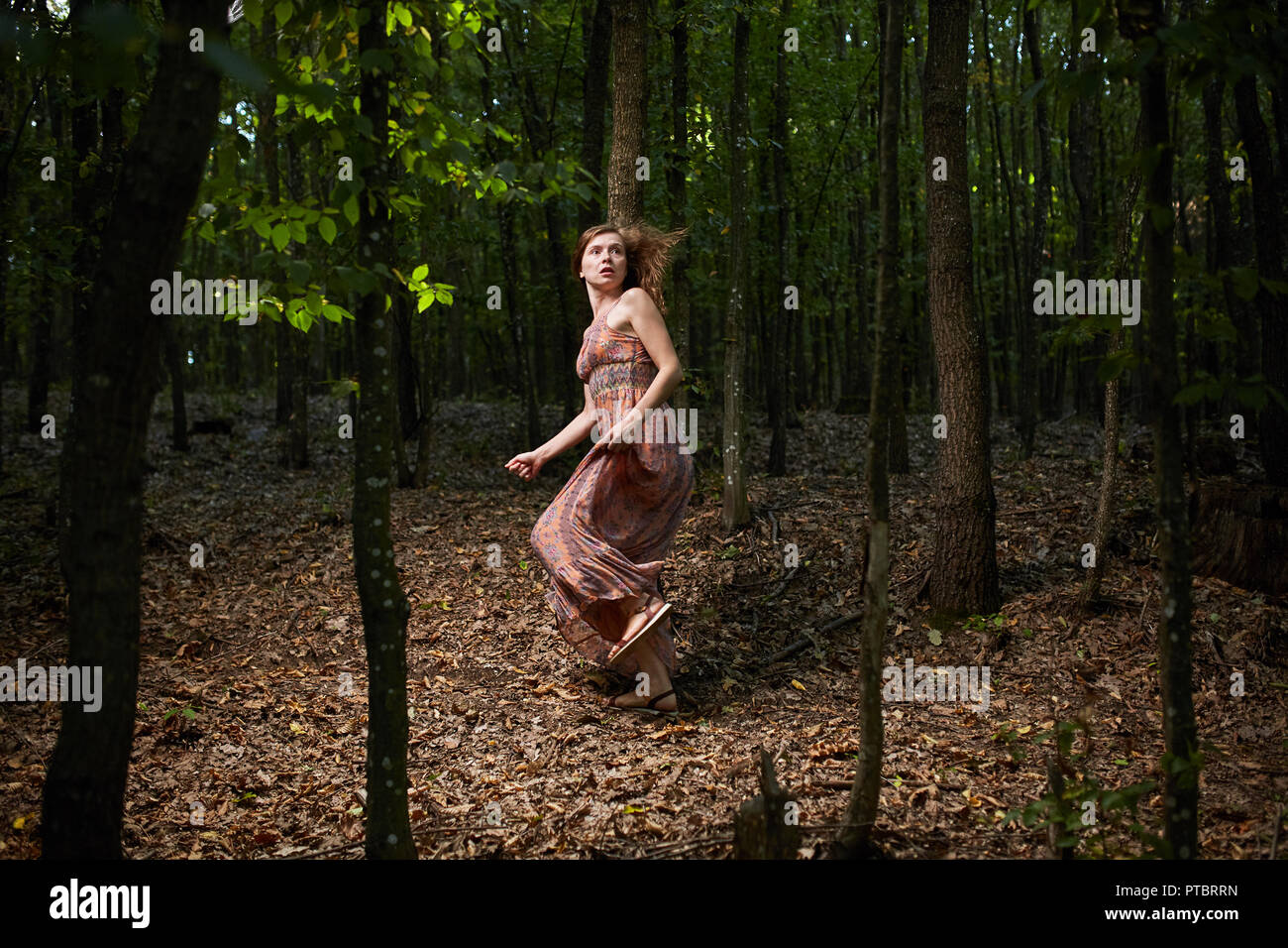 Scared woman running through the forest Stock Photo - Alamy