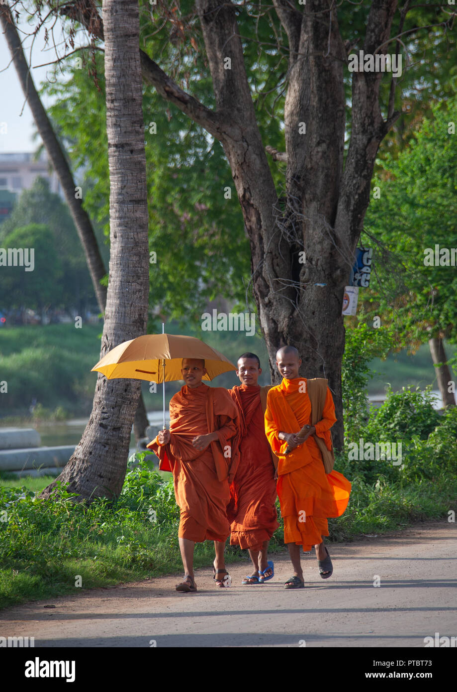 Cambodian monk walking in the street with umbrella, Battambang province ...