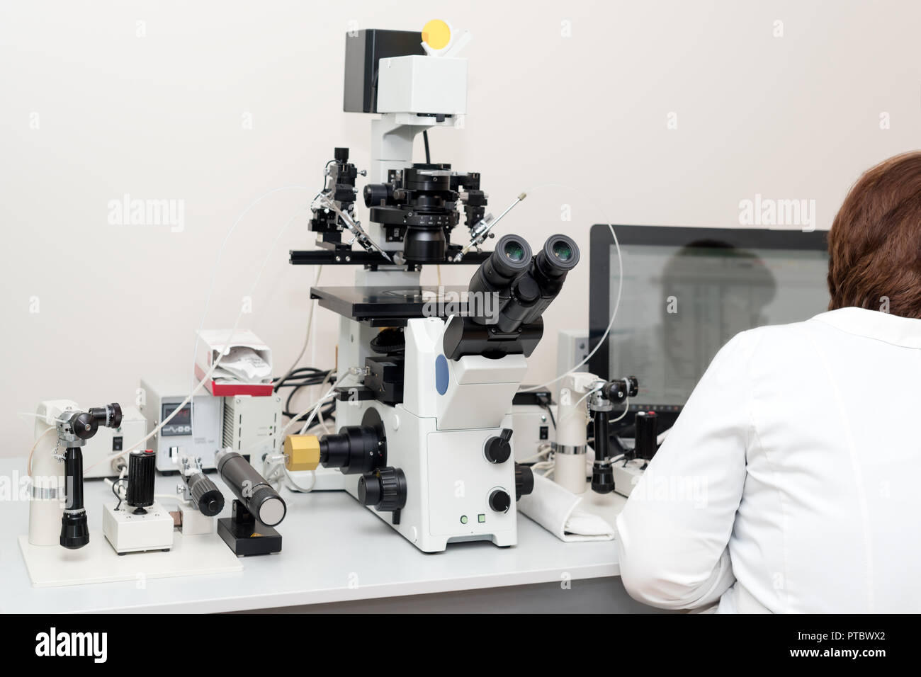 Doctor or scientist working with computer and microscope in biotech lab ...