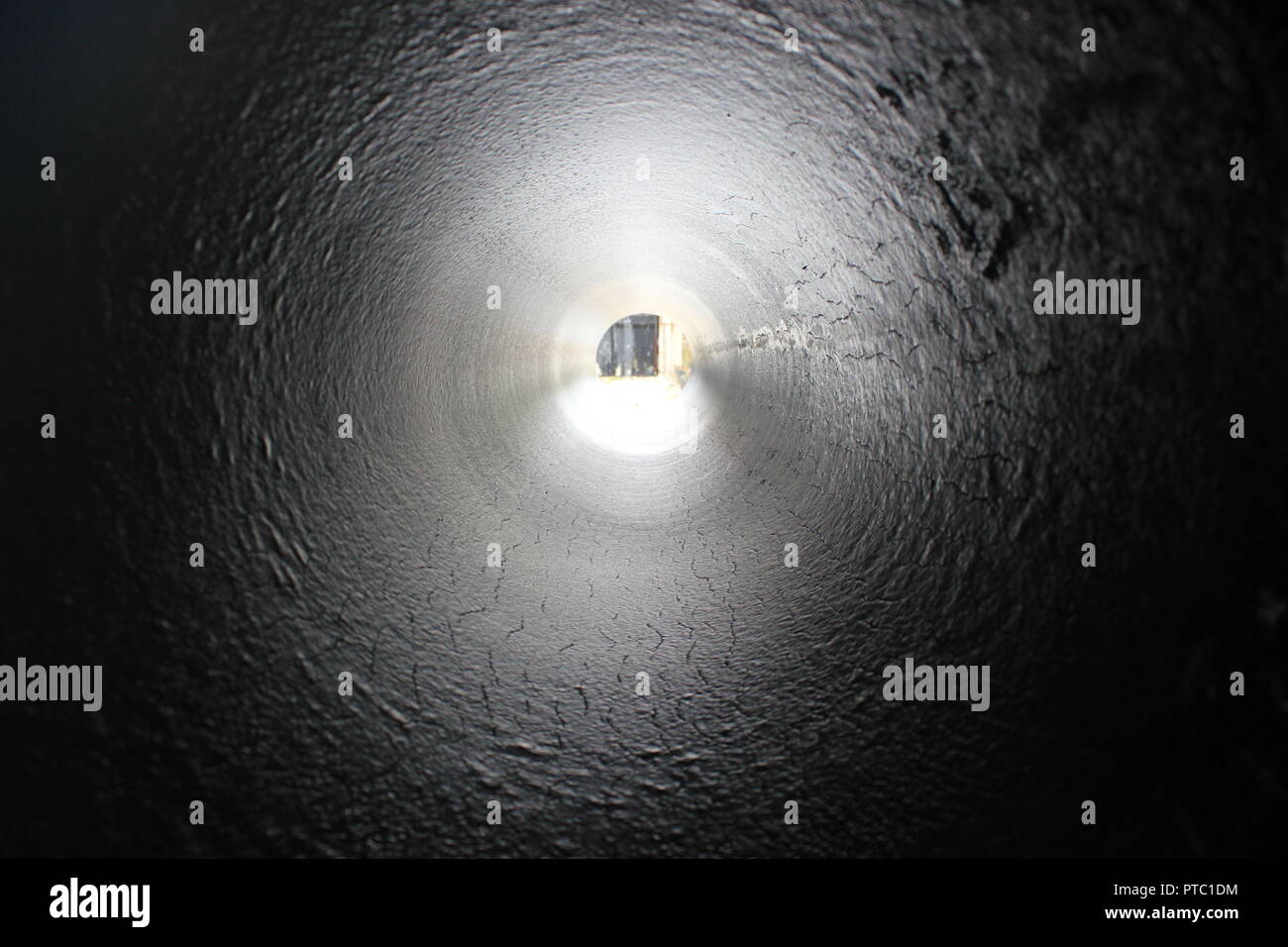 Looking inside a long black pipe with light at the end of the line ...