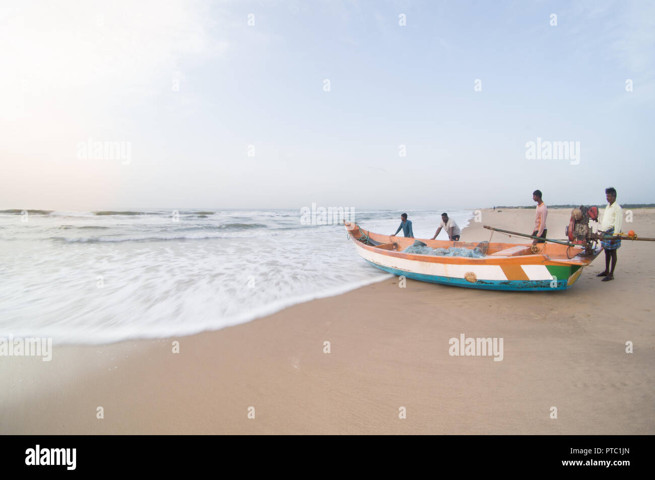 Fisher men on a fishing boat on the beach Stock Photo - Alamy