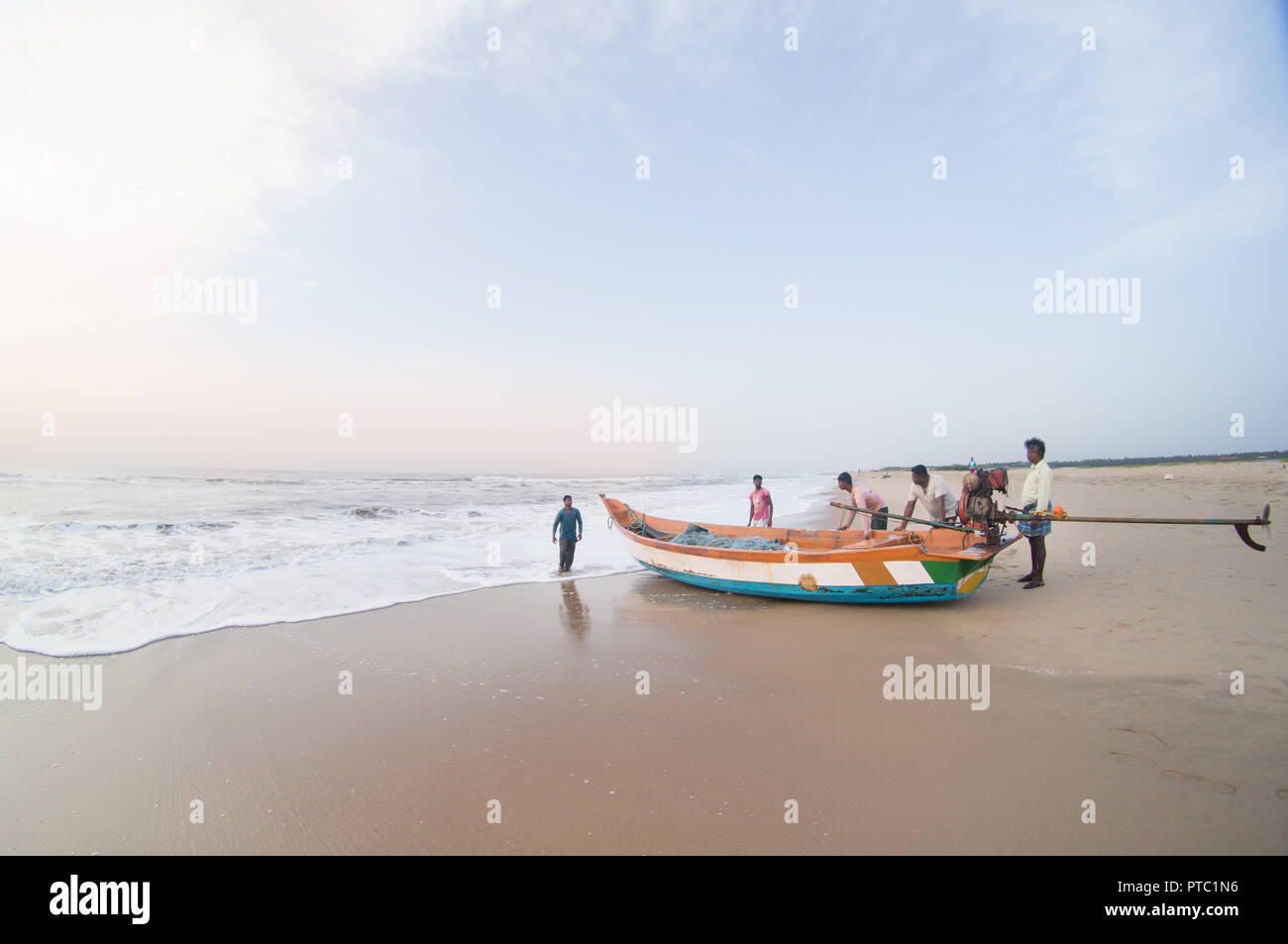 Fisher men on a fishing boat on the beach Stock Photo - Alamy