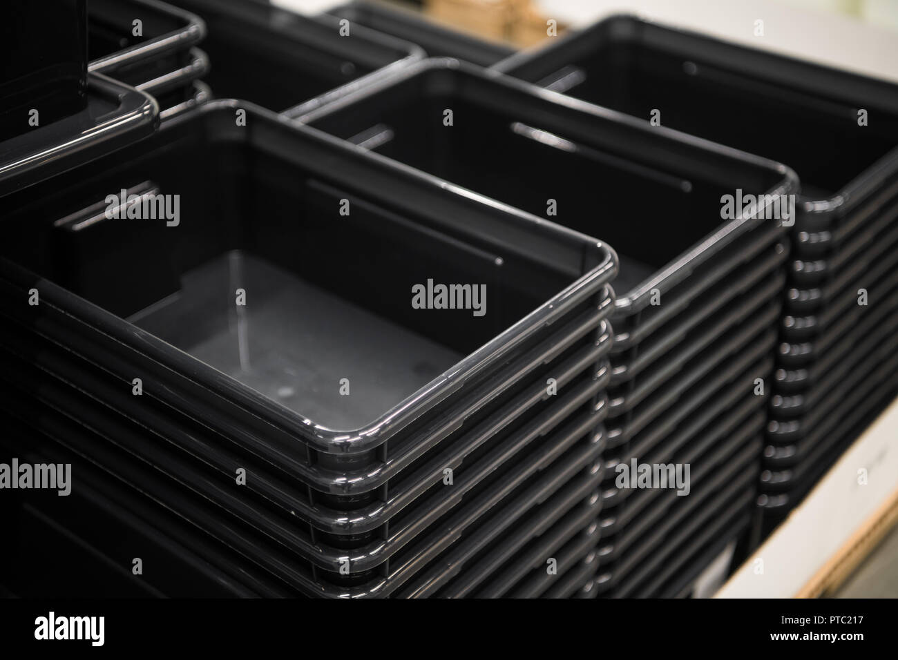 Black plastic box containers in row at store Stock Photo - Alamy